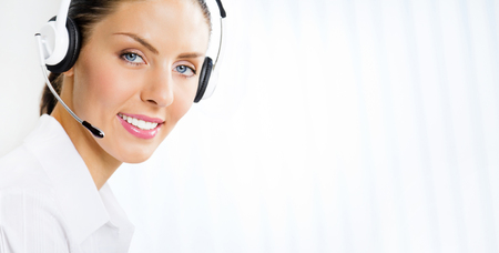 Portrait of happy smiling support phone operator in headset at office. Blank copyspace area for ...