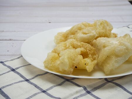 Dried fish maw in a white plate with napkin on a wooden table in the ...