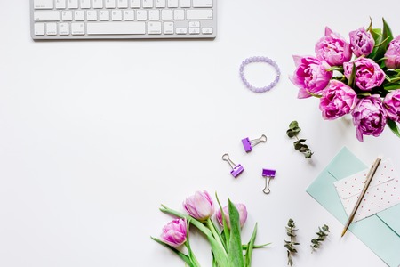 Flowers on trendy desk in office white background top view mock up ...