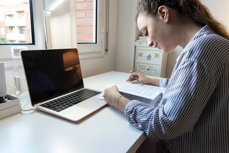 Young attractive woman doing homework sitting desktop with modern ...