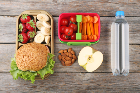 School lunch in boxes with bottle of water on wooden table - Stock ...