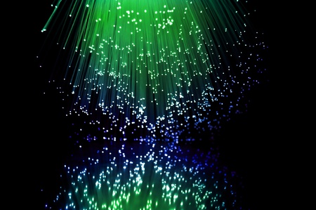 Green and blue fibre optic light strands reflecting in the foreground ...