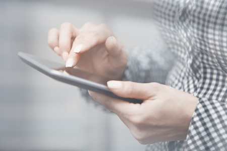 Woman at office behind the glass door working with digital tablet ...