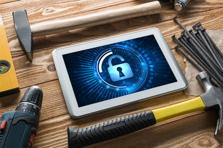 Tablet pc with security concept on screen and industrial tools around ...