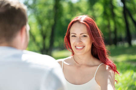 Portrait of a young attractive woman on a date in a park. Spending time ...