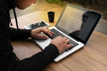 Cropped shot Silhouette of a man's hands using a laptop at home, rear ...