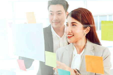 Young businesswoman office worker reading sticky notes on planning ...