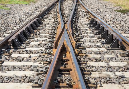 Close up two rusty old steel railway track switch,point two paths come ...