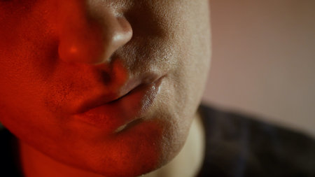A young man with a serious look. Frowning man in red tones evil smileの ...