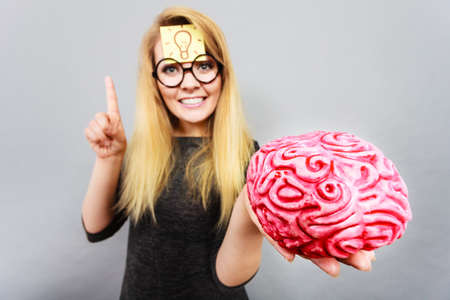Weird blonde woman holding brain having something on mind, thinking of ...