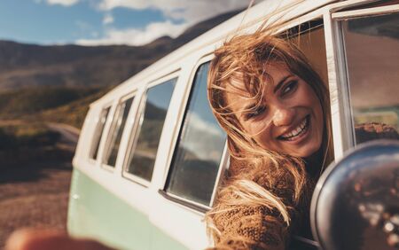 Happy woman on road trip driving a van and laughing. Smiling caucasian ...