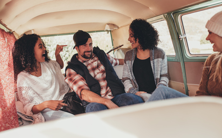 Diverse friends on roadtrip travelling together in a van. Group of man ...
