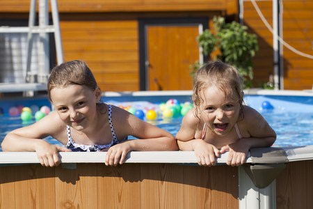 Two Happy sisters in bikini swimming pool - Stock Image - Everypixel