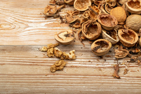Cracking nuts on a wood table close up. Macro photo of crushed walnuts ...