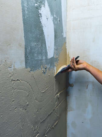House improvement by worker. Hand with a spatula. Worker trowels putty ...