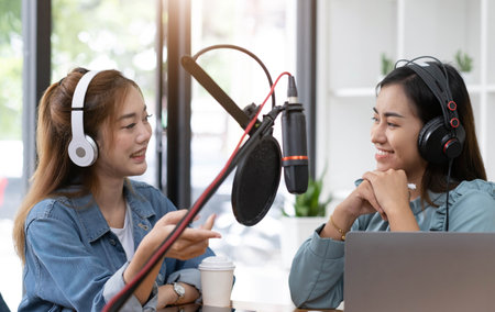 Smile two asian young woman, man radio hosts in headphones, microphone ...