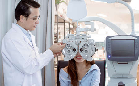 Ophthalmologist doing eyesight test to a woman in optical laboratory ...