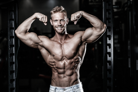 Handsome power athletic man on diet training pumping up muscles with ...