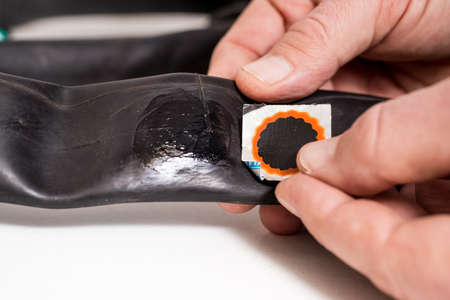 Bicycle inner tube repair. A person is applying vulcanization patch on ...