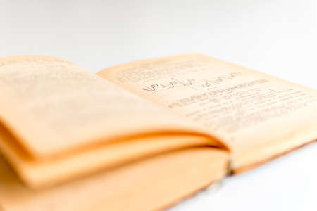 Close up shot of an open old science book containing equations and ...