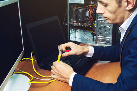 man in suit holding network cables in the background wiring of the ...
