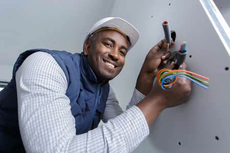 happy man working with pliers at house wall wires - Stock Image ...