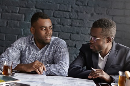 Two African partners having lively conversation while discussing ...