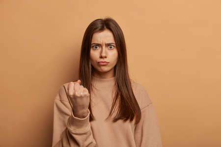 Photo of angry Caucasian woman clenches fist, comes to argue, complains ...