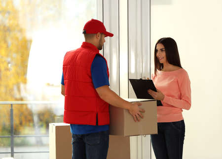 Receiving parcel - delivery man gives package to young woman - Stock ...