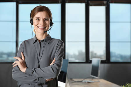 Female technical support operator with headset in office. Space for ...