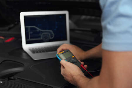 Mechanic with laptop doing car diagnostic at automobile repair shop ...