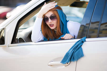 Young fashionable woman driver has her scarf jammed in vehicle doors ...