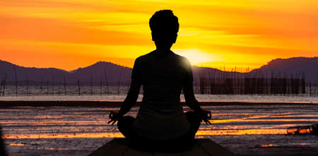 The silhouette of woman sitting yoga alone,Relax and meditate,mental ...
