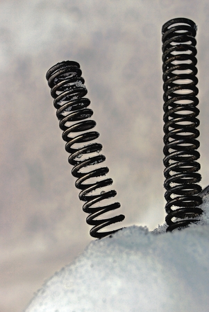 two black steel springs in the snow - Stock Image - Everypixel