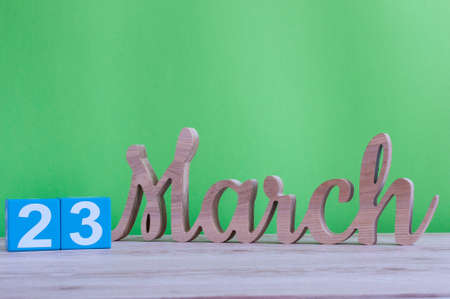 March 23rd. Day 23 of month, daily wooden calendar on table and green ...