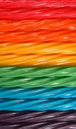 A closeup/macro photograph of licorice twists in a variety of colors ...