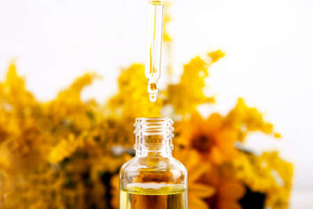 Drop falling from dropper of essential oil, aromatherapy essence ...