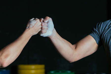 Cropped view of the hands of sporty couple hitting their fists on a ...