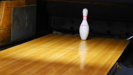 Close-up view of white pins standing in th end of bowling alley lane ...