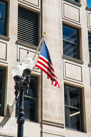 An American flag hanging on a traditional stone building and a black ...