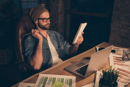 Photo of attentive guy work at dark time making notes of corporate ...