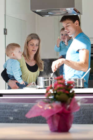 Young family cooking in a modern kitchen setting - Stock Image - Everypixel