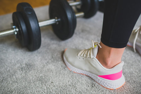 Woman is preparing to work out with dumbbells. Home fitness training ...