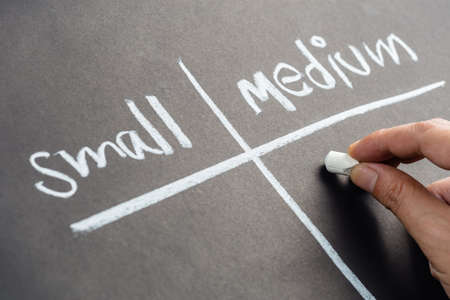 Hand writing divided chart of Small and Medium for comparison, SME or ...