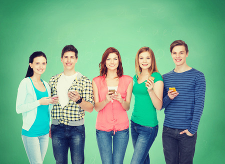 education and modern technology concept - smiling students with ...