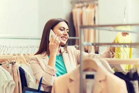woman calling on smartphone at clothing store - Stock Image - Everypixel