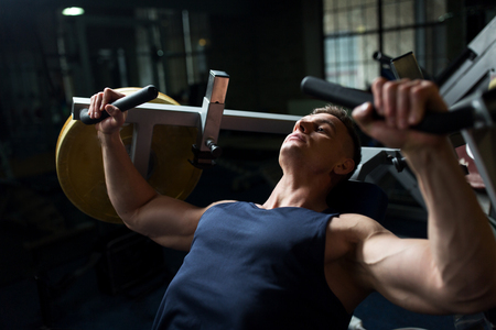 man doing chest press on exercise machine in gym - Stock Image - Everypixel
