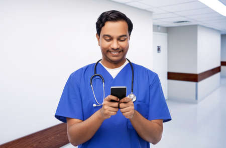 smiling doctor or male nurse using smartphone - Stock Image - Everypixel