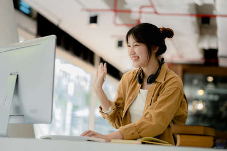 Beautiful Asian woman using a computer to study online, she is studying ...