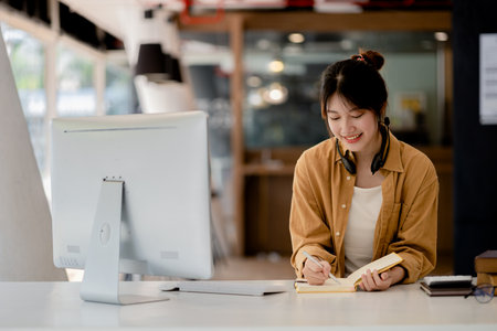 Beautiful Asian woman using a computer to study online, she is studying ...